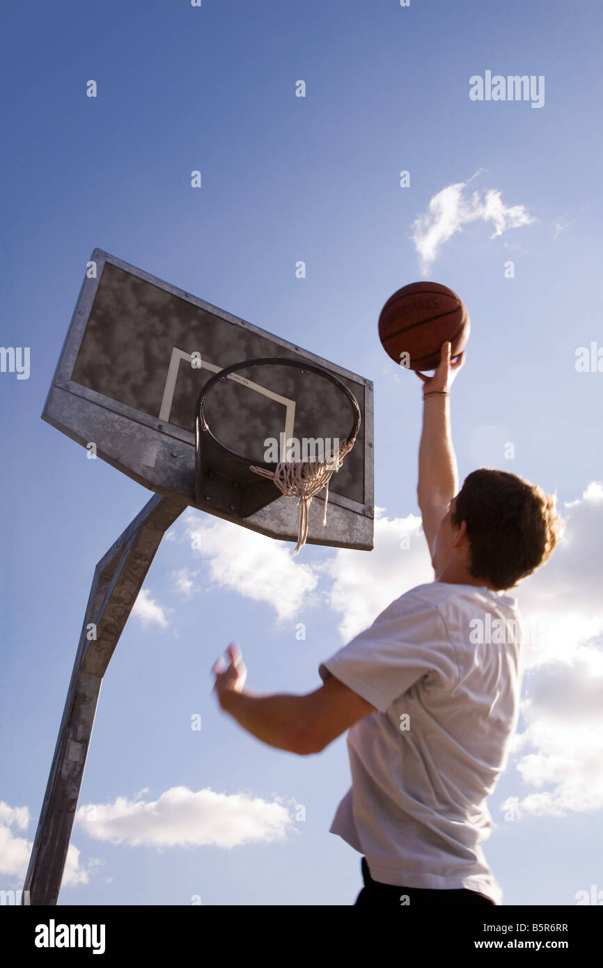 rear view of a male youth shooting a hoop playing basketball Stock ...