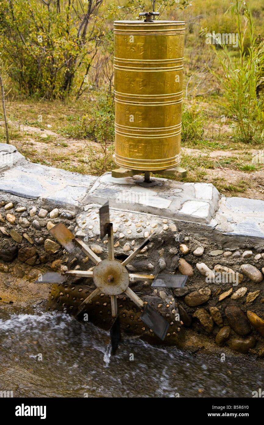 Tibetan Buddhist brass prayer wheel driven by the flow of water in a ...