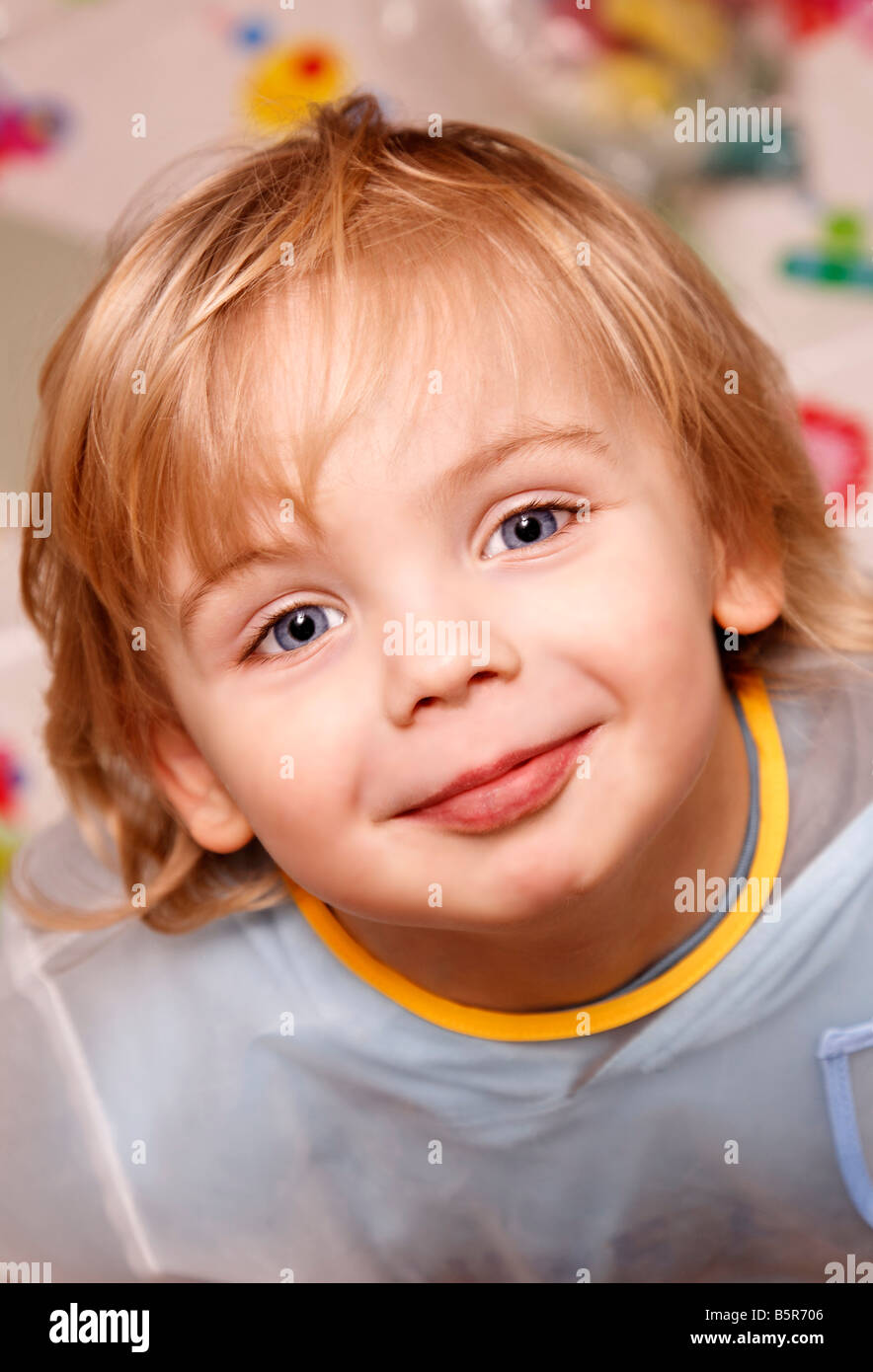 blond good looking smiling child with blue eyes looking up wearing a ...
