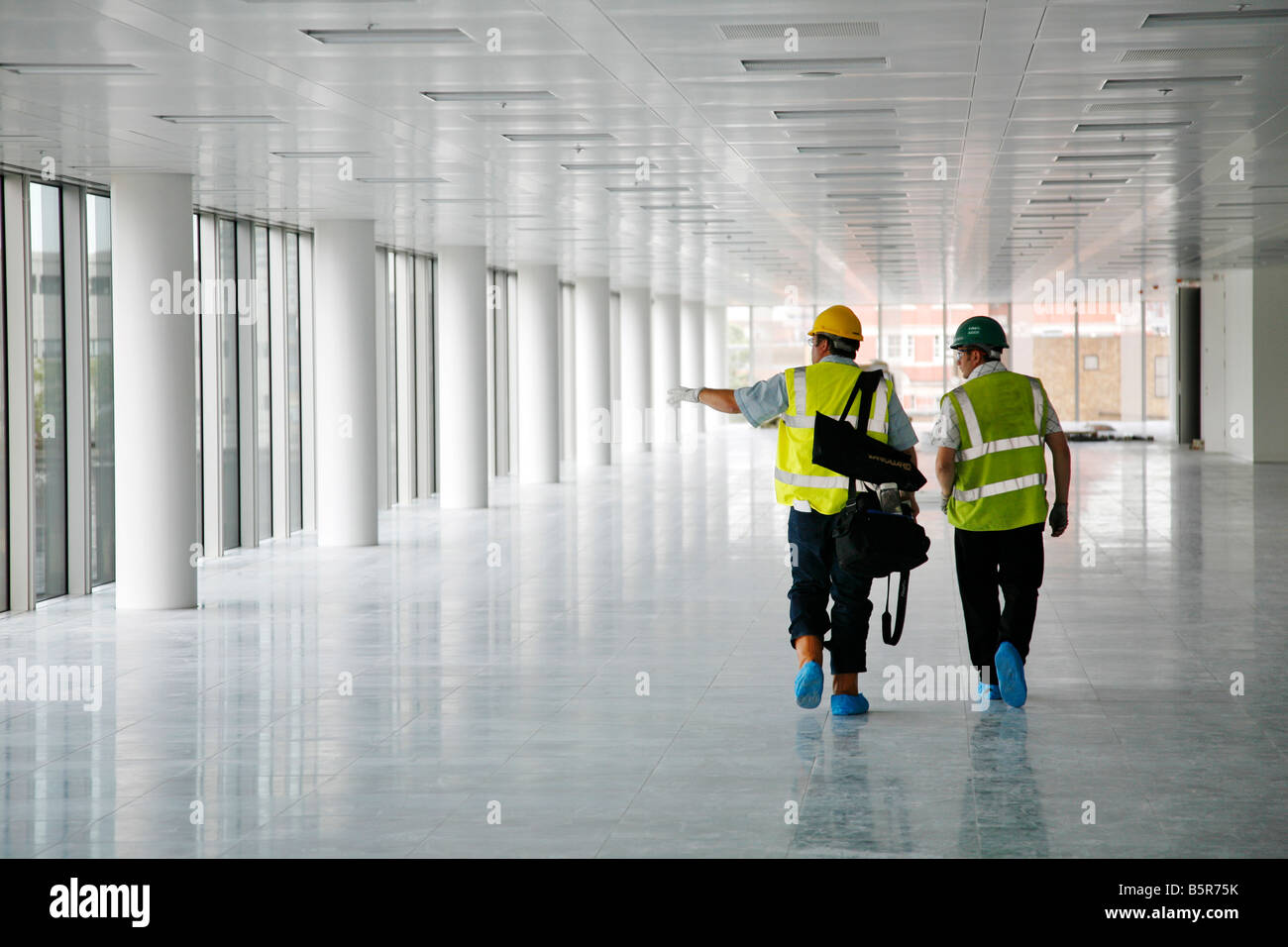 building site white empty office with two workers wearing fluorescent ...