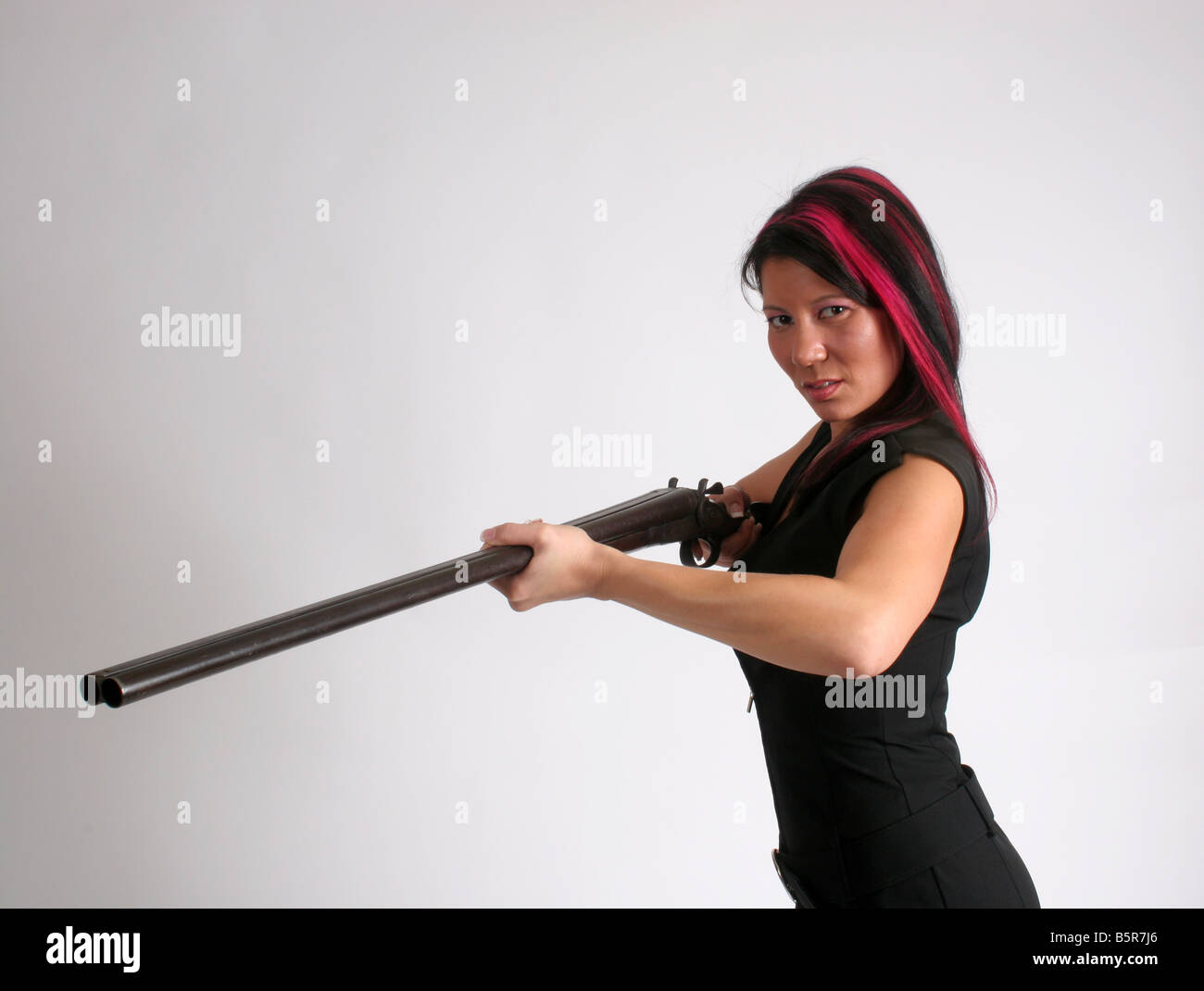 Woman aiming a shotgun to the left Stock Photo - Alamy