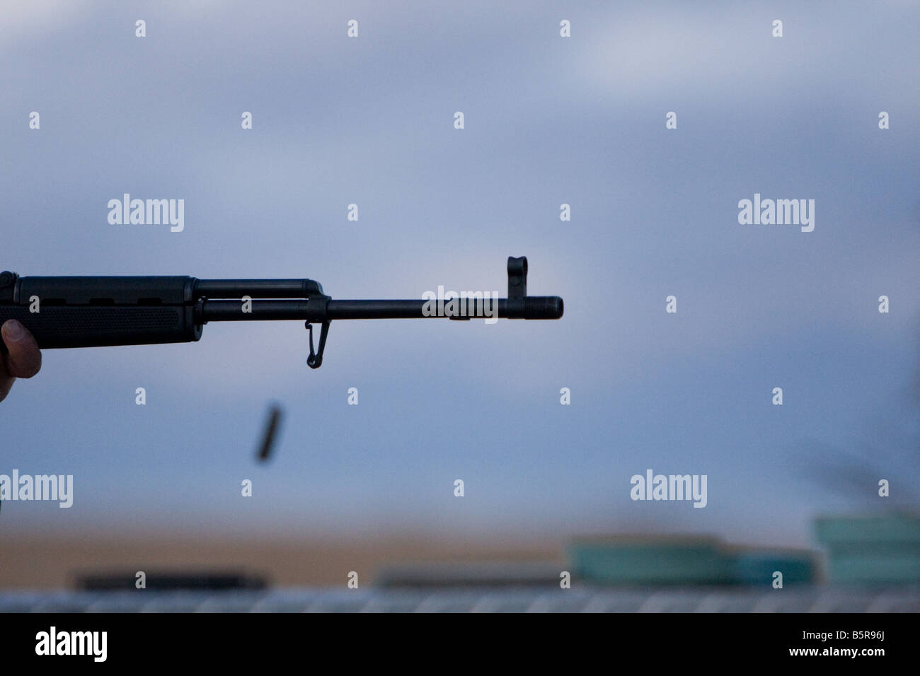 Close up of a semi-automatic rifle being fired with shell casing flying ...