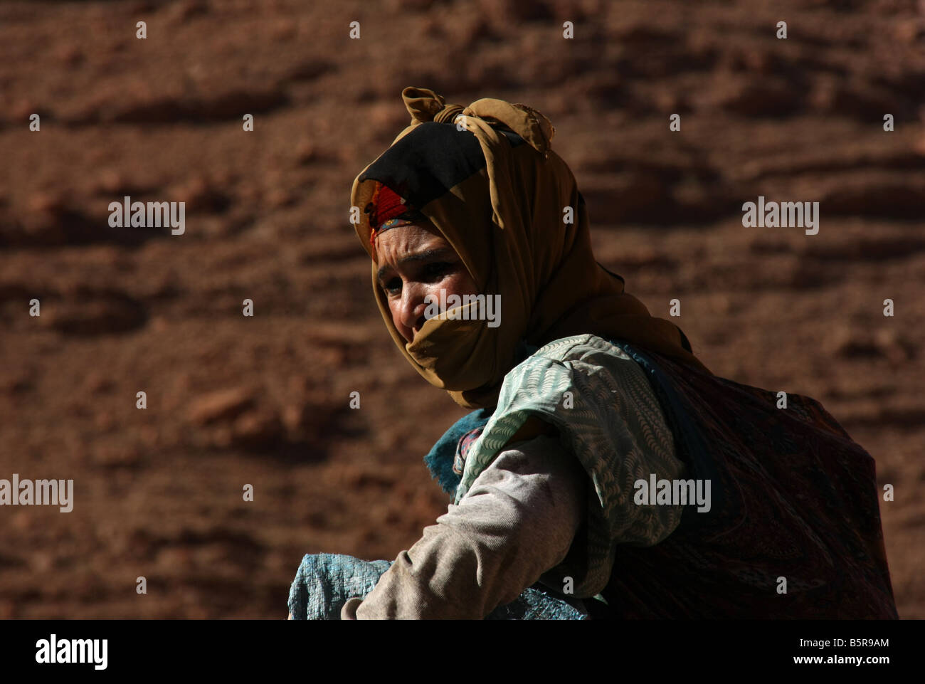Berber woman in traditional clothing high in the Atlas Mountains ...