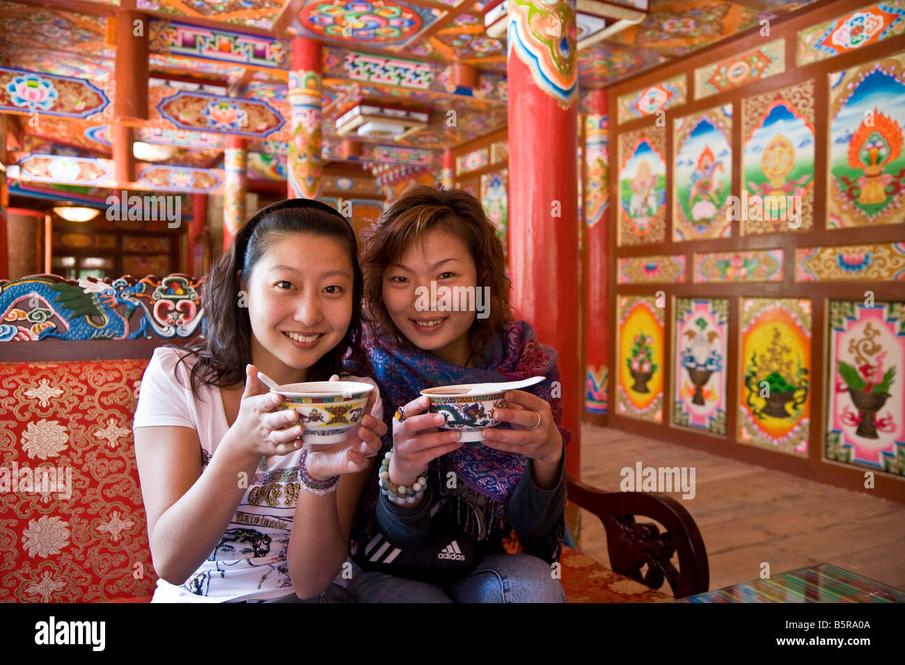 Two young Chinese women drinking tea in painted Tibetan tea house in ...
