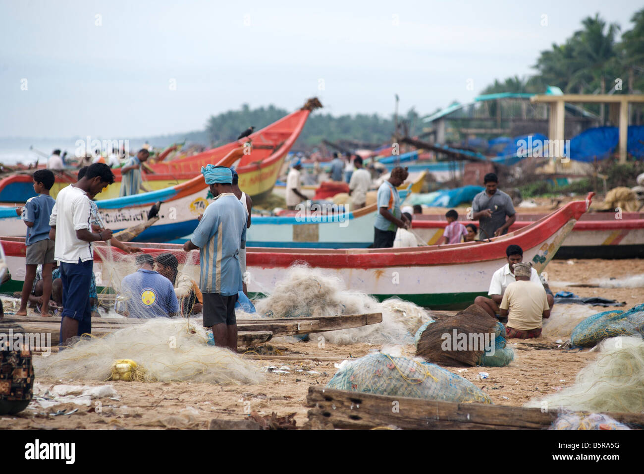 Fishermen and fishing boats on Kalapet beach near Pondicherry in India ...