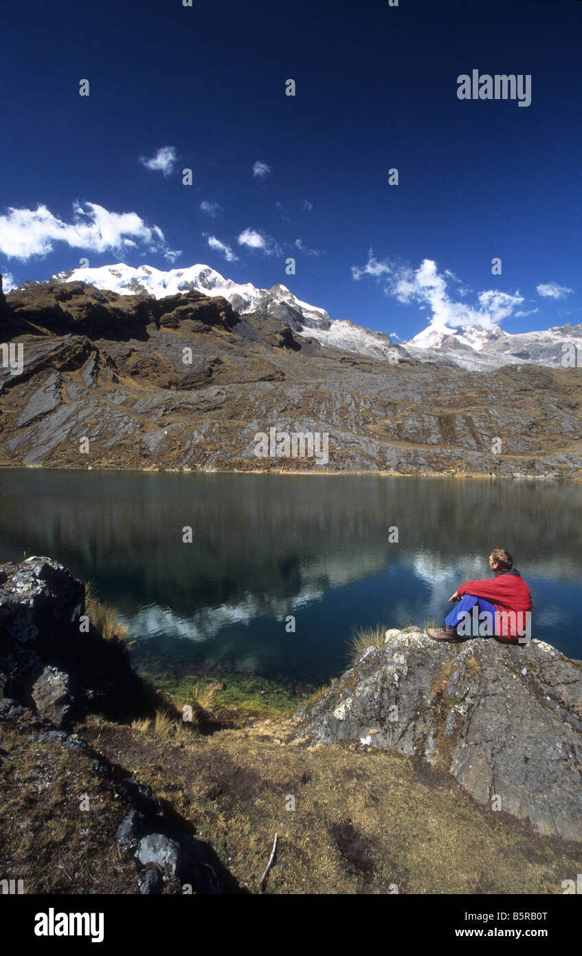 Trekker looking at view across Lake Chillata, Mts Illampu and Ancohuma ...