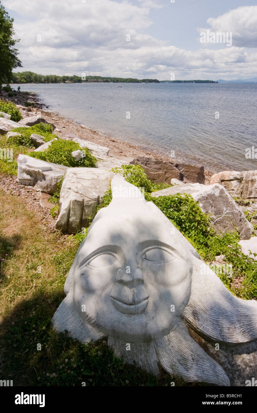 Face carved into a rock on the edge of a large lake Stock Photo - Alamy