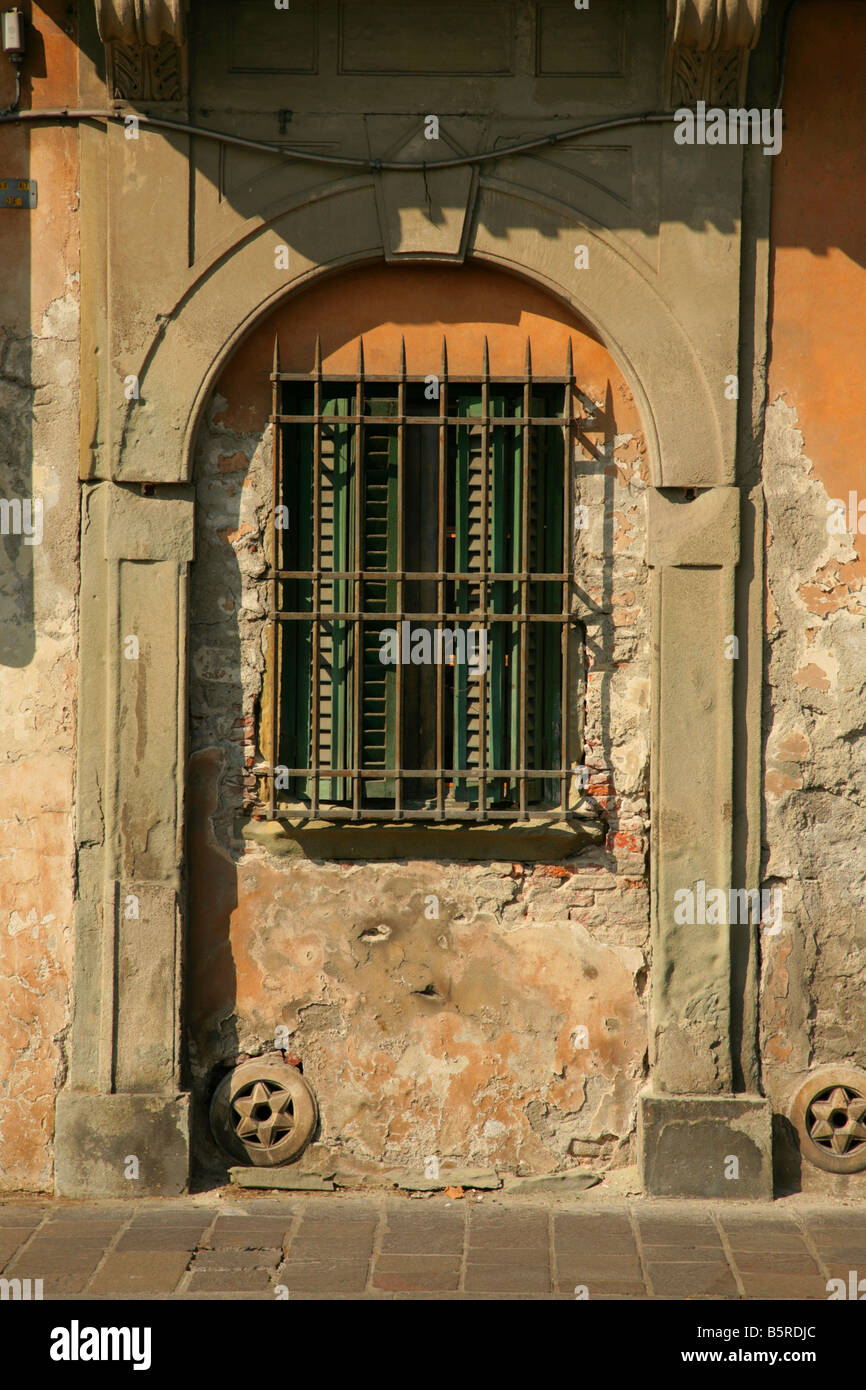 Barred and shuttered window on old stone building in Pisa, Italy Stock ...