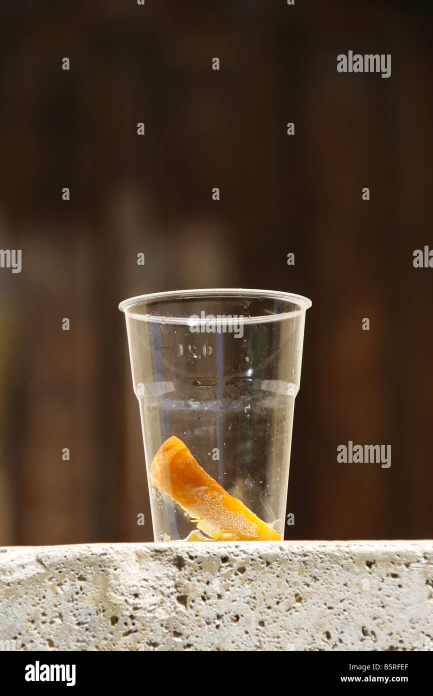one empty plastic glass on wall by river in sun Stock Photo - Alamy