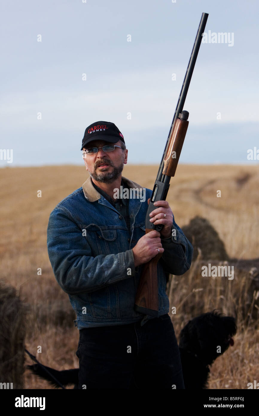Man holding a rifle in a field Stock Photo - Alamy