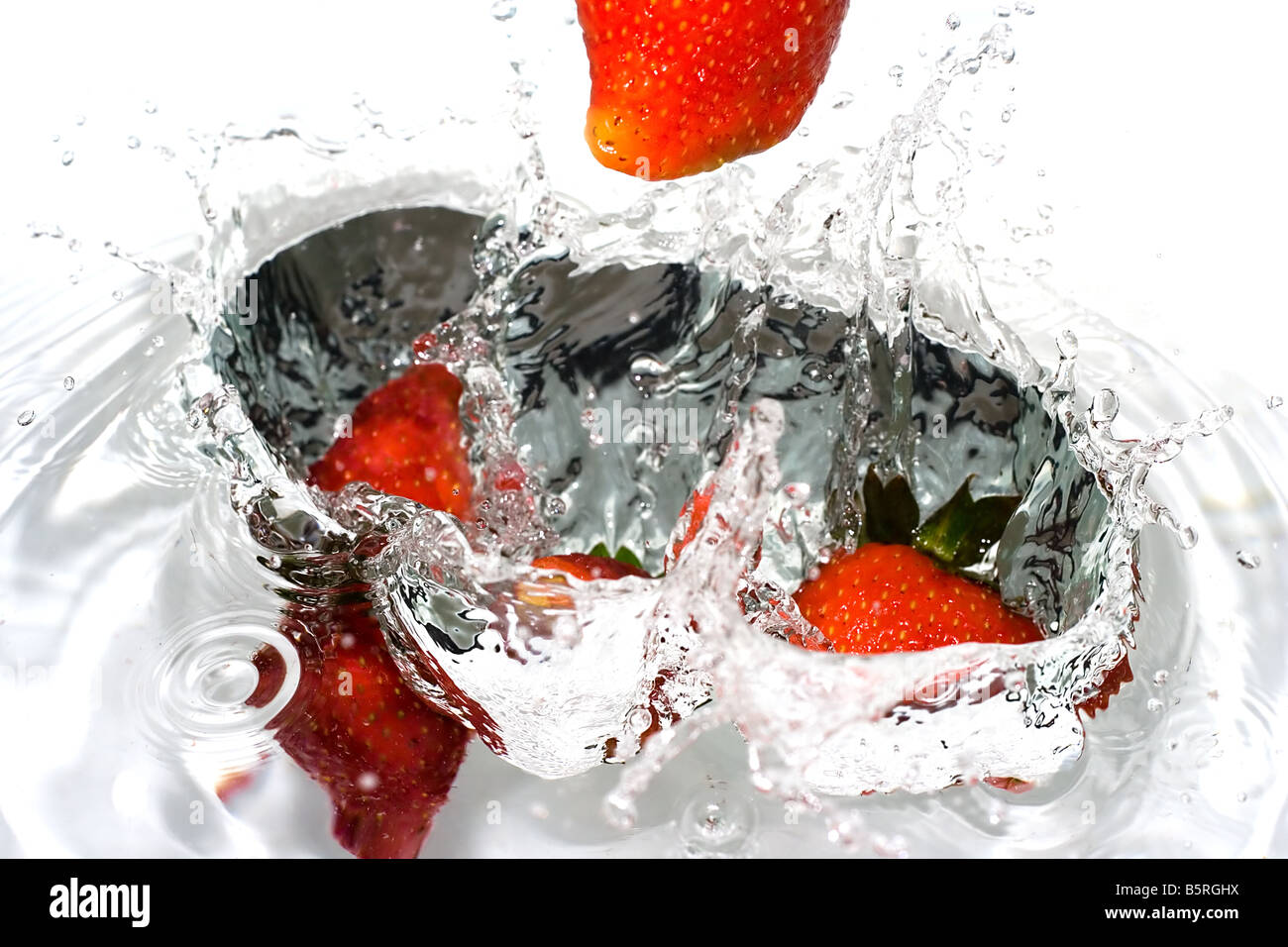 Strawberrys falling into liquid Stock Photo - Alamy