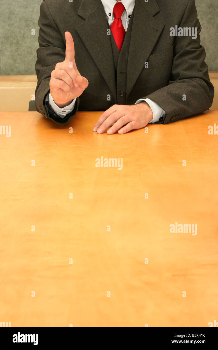 Business man sitting at the desk fingers indicating first Stock Photo ...