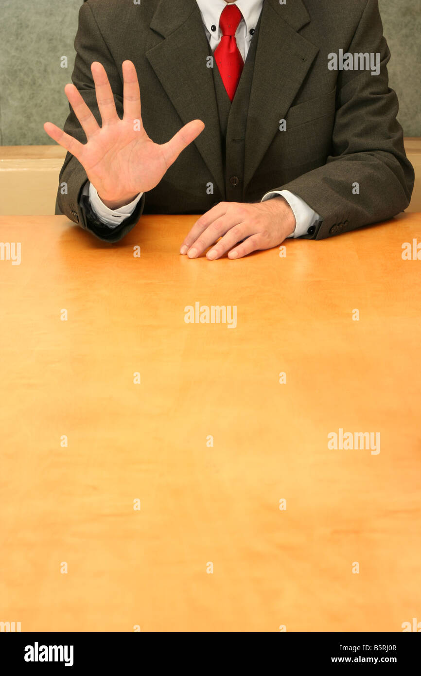 Business man sitting at the desk making a five or wait Stock Photo - Alamy