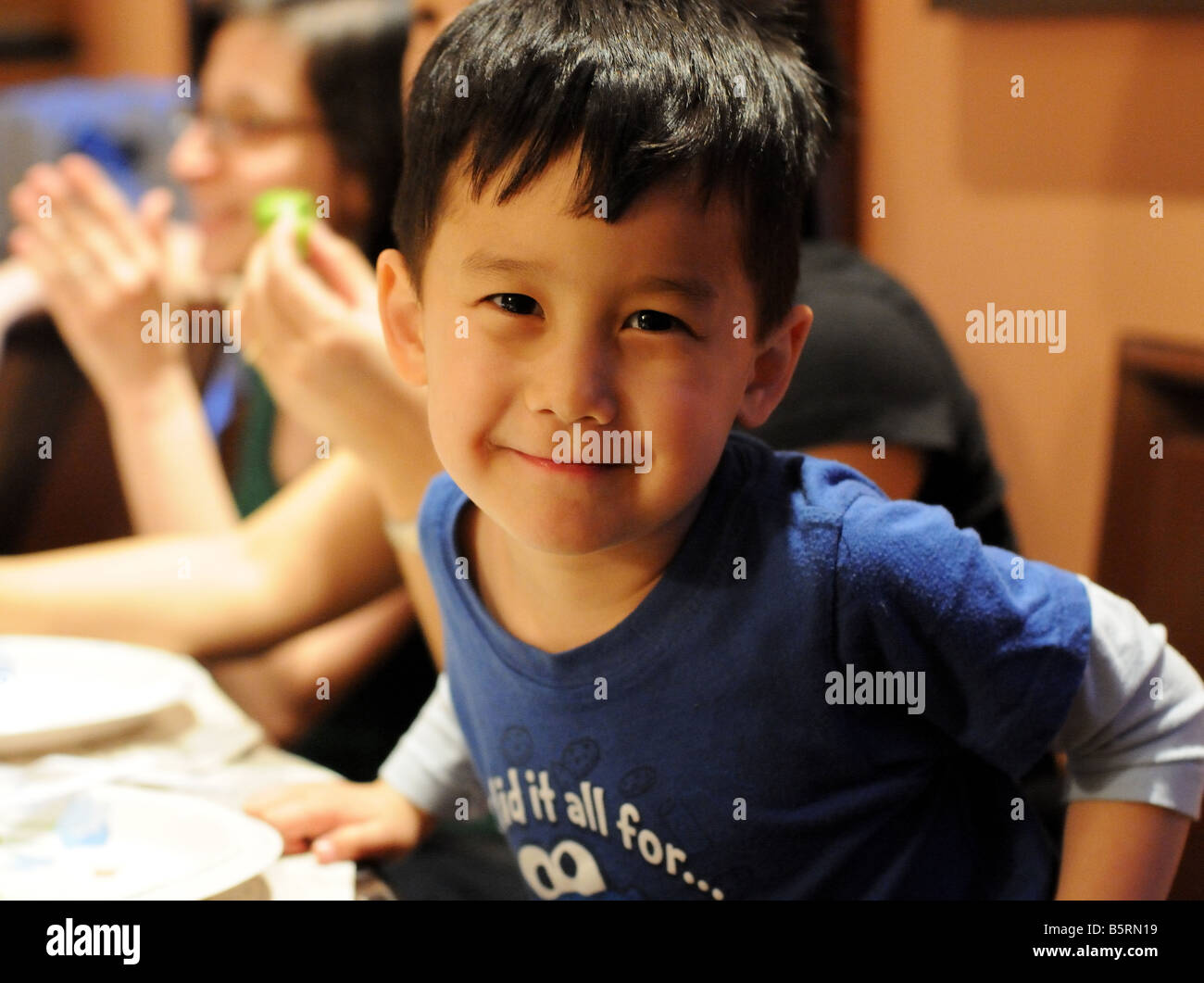 An absolutely adorable child, Caucasian, Asian, staring into the camera ...