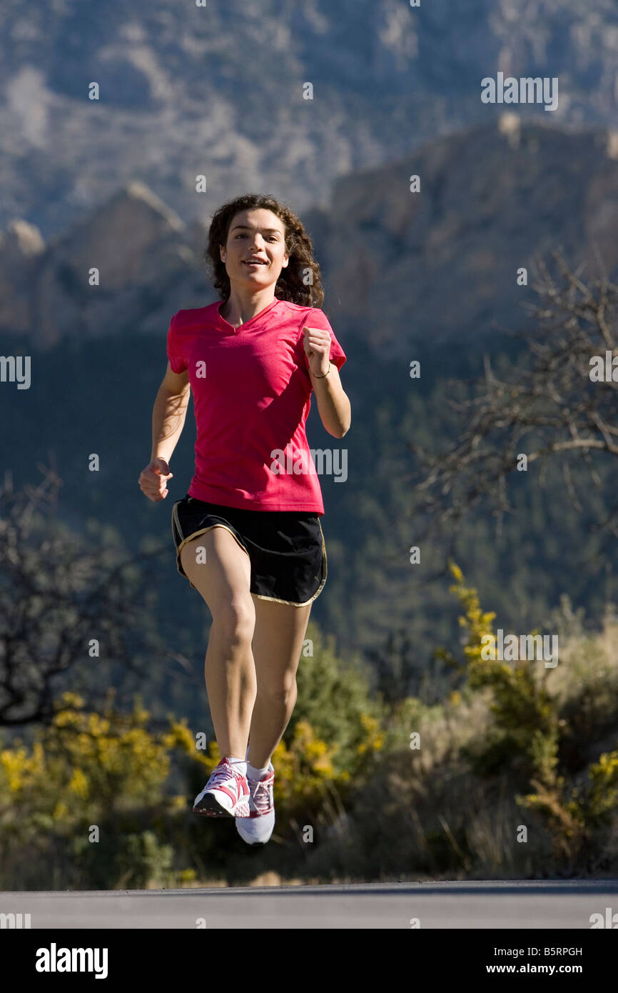 Female runner on mountain road Stock Photo - Alamy