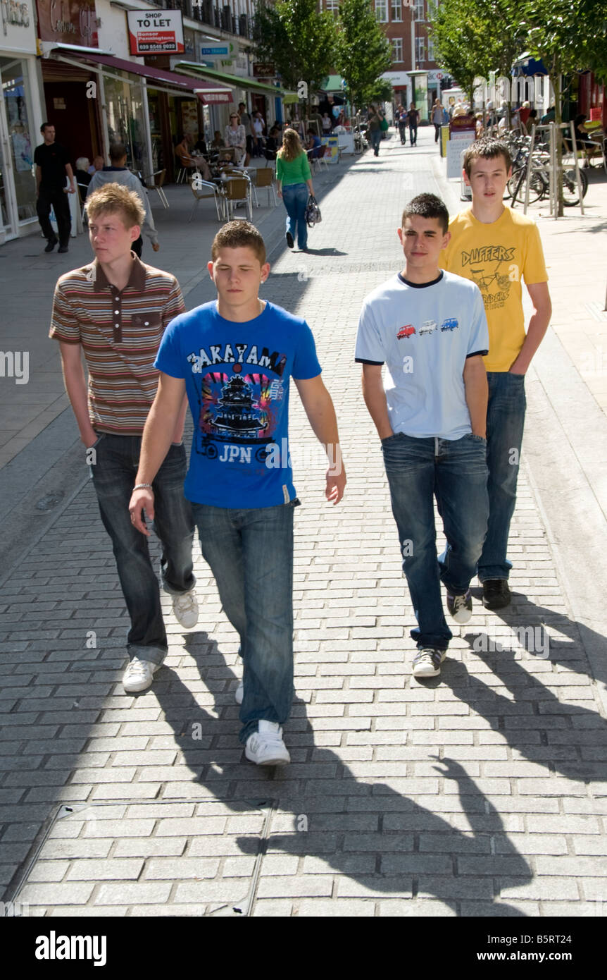 gang of teenage boys following another boy down the street Stock Photo ...