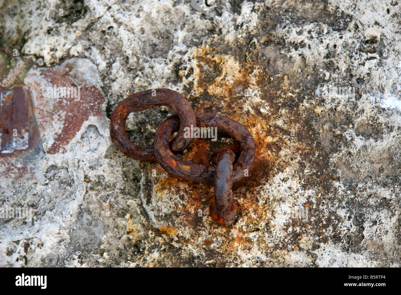An old metal hook to secure boats on the harbor side Stock Photo - Alamy