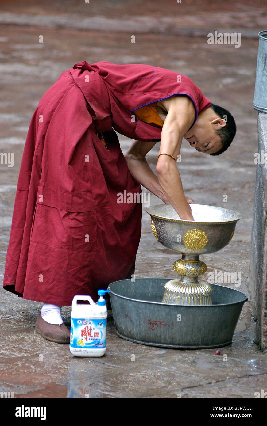 Monk washes religious vessel at the Jokhang monastery, Lhasa, Tibet ...