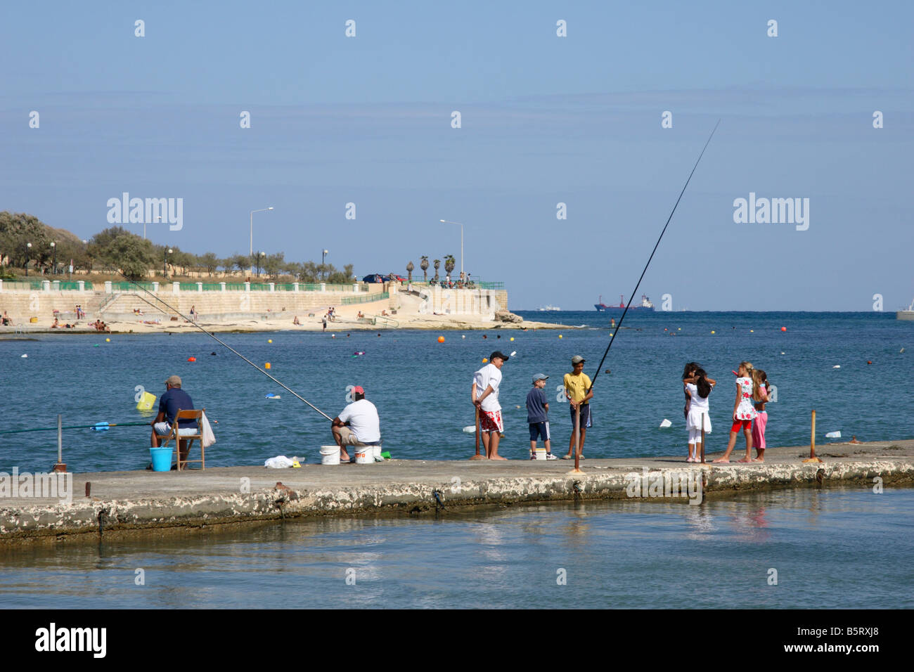 Local Maltese fishing from a jetty at "St Thomas Bay" near Marsaskala ...