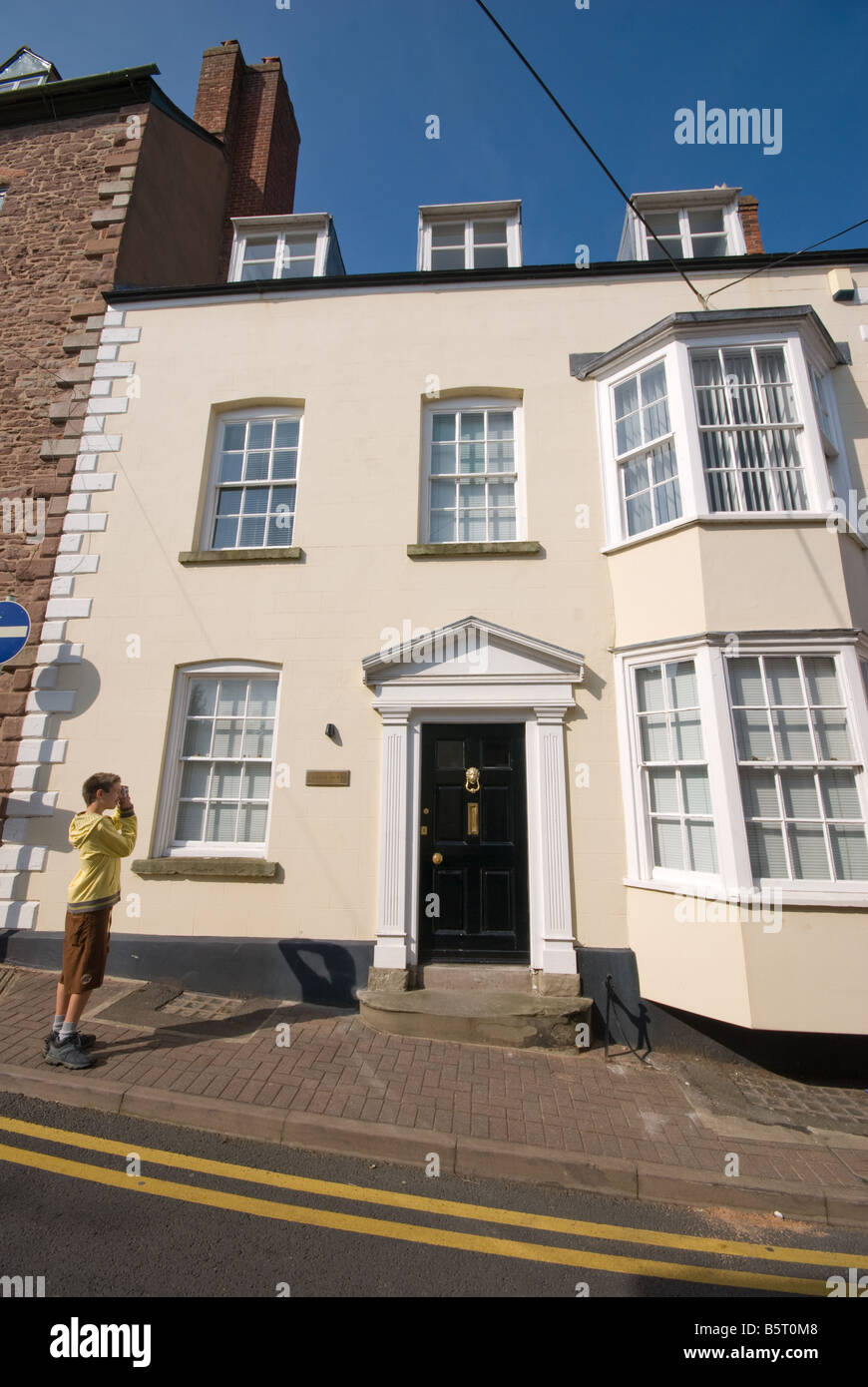 Boy photographing the front of a traditional period Georgian house ...