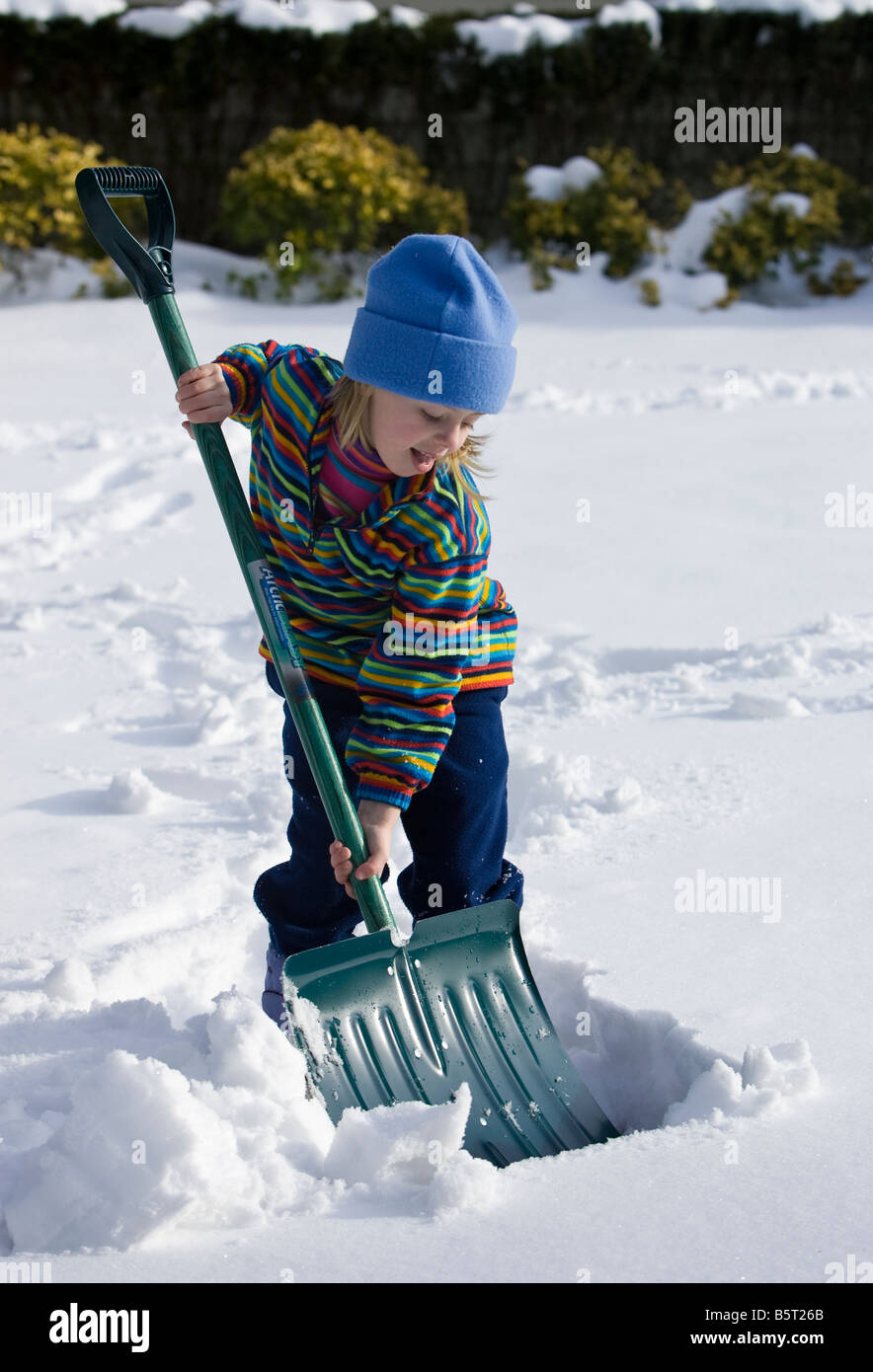 Child digging snow with a shovel Stock Photo - Alamy