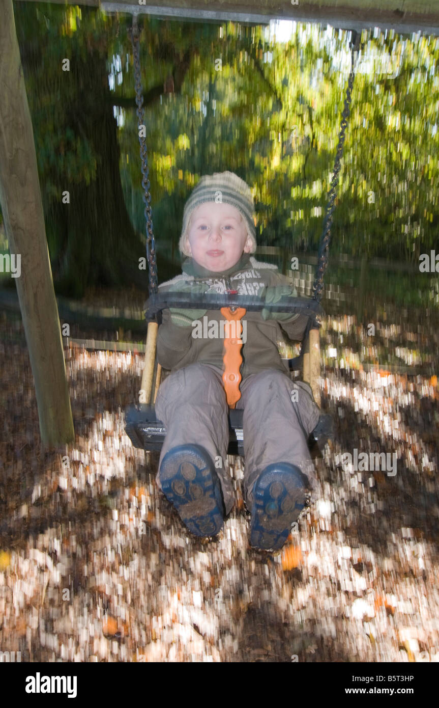 Boy swinging on swing Stock Photo - Alamy
