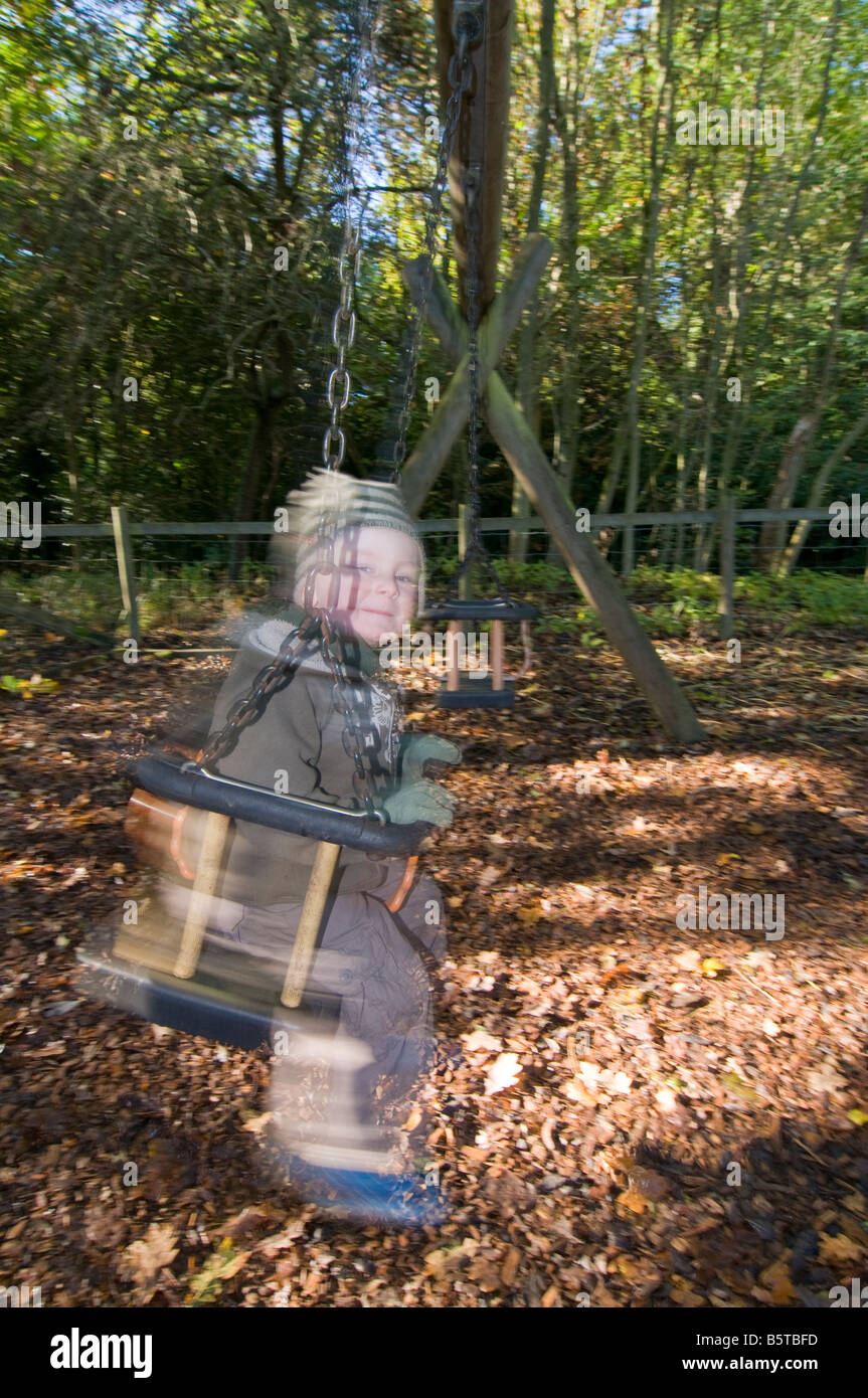 Boy swinging on swing Stock Photo - Alamy