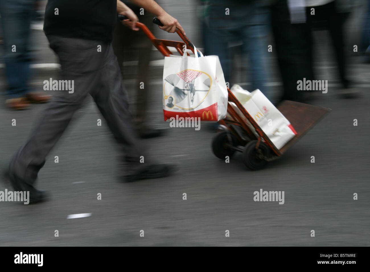 man pushing trolley with macdonalds take away food bags Stock Photo - Alamy