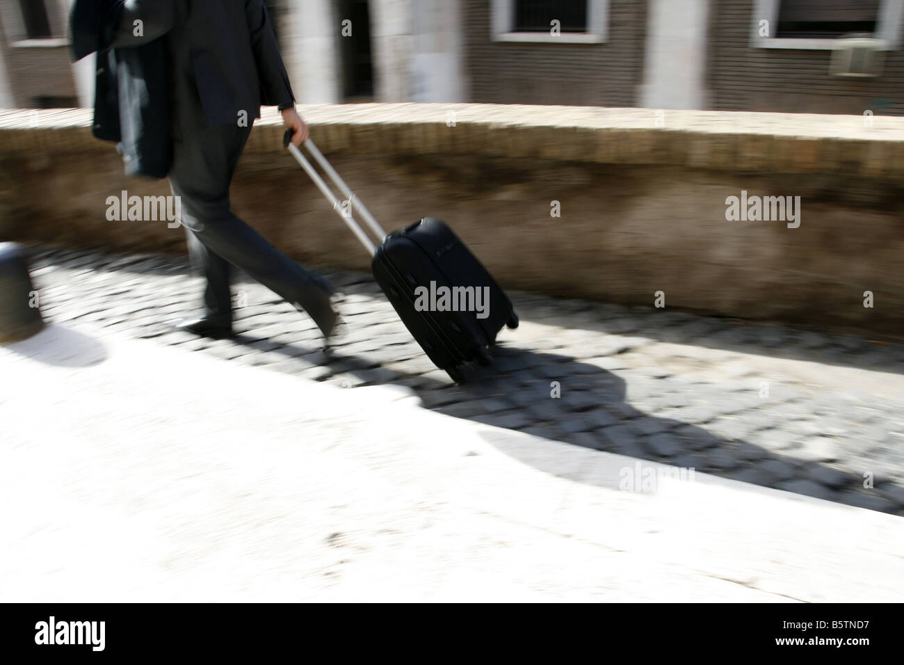 business man pulling trolley luggage case in town Stock Photo - Alamy