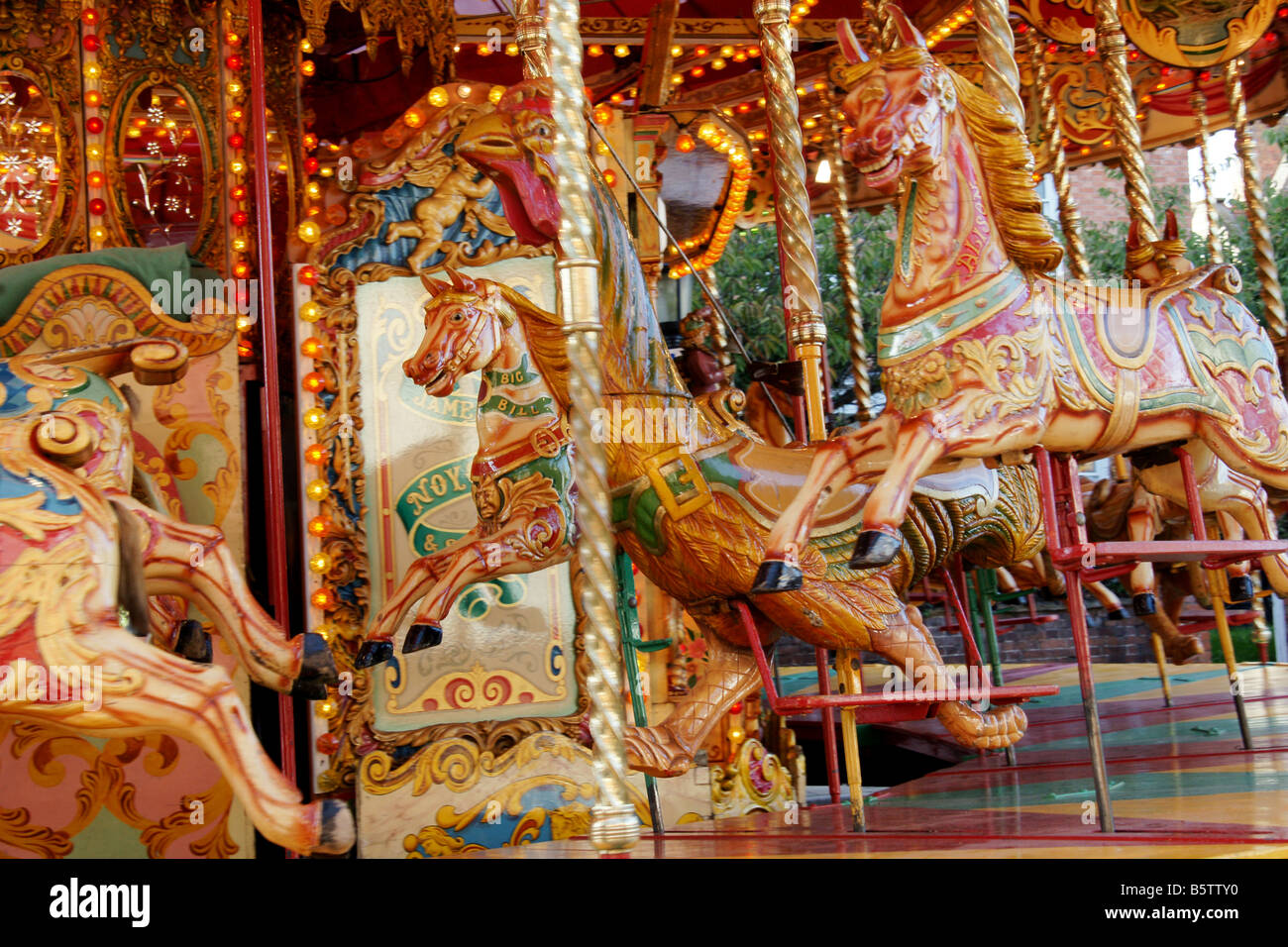 Old Fashioned Carousel Ride, with lights and brightly coloured horses ...