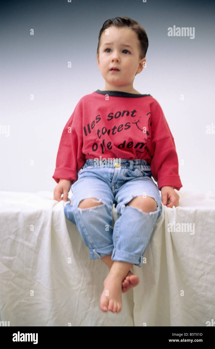Little boy sat with his jeans torn in knee Stock Photo - Alamy