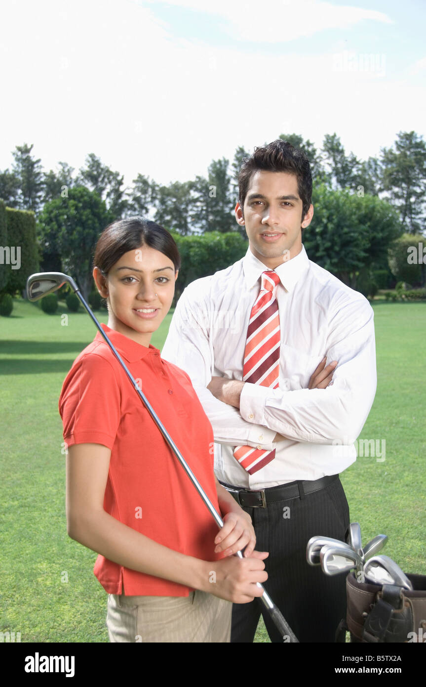 Couple standing in a golf course Stock Photo - Alamy