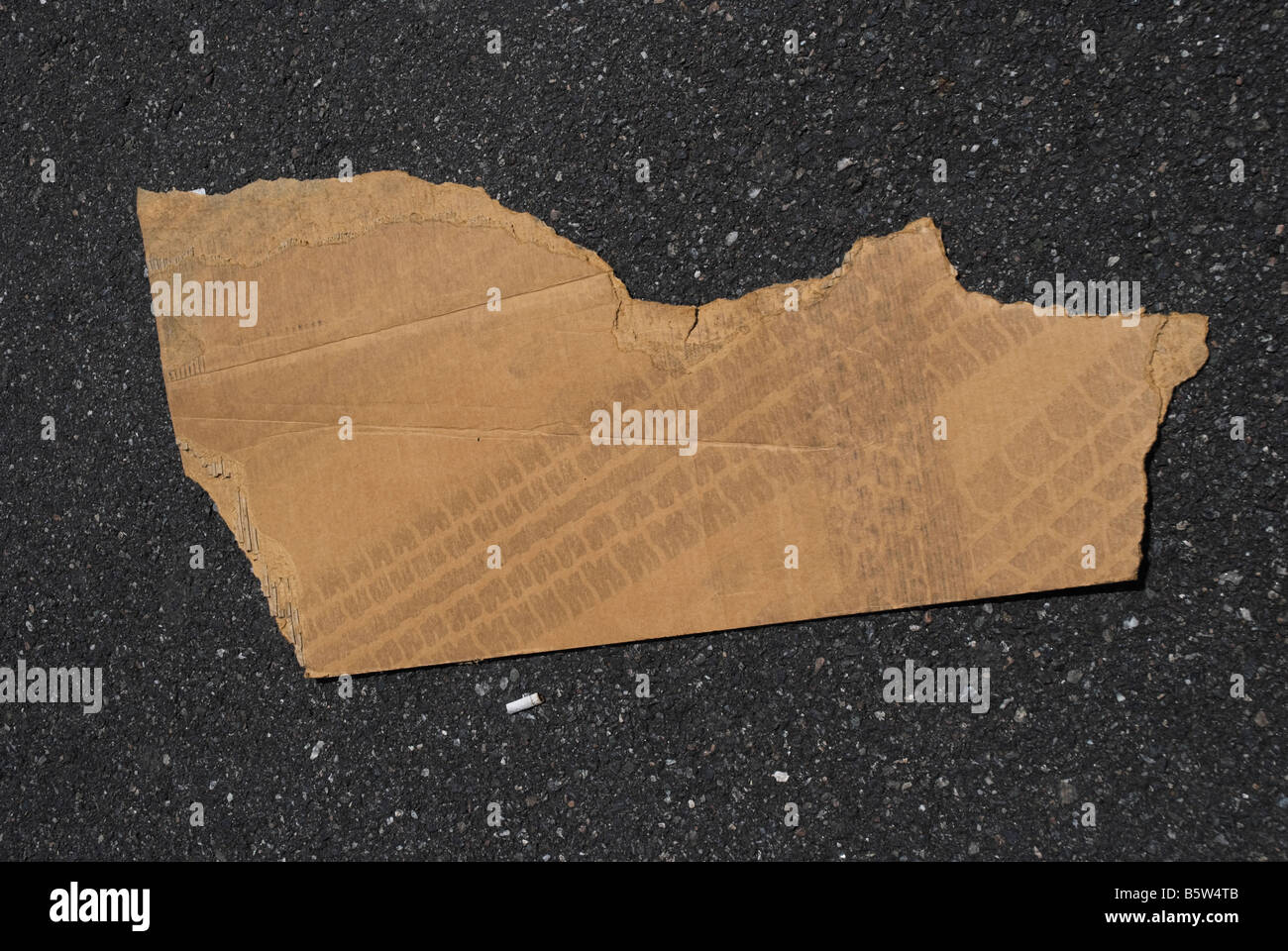hunk of cardboard debris with tire marks on it in parking lot Stock ...