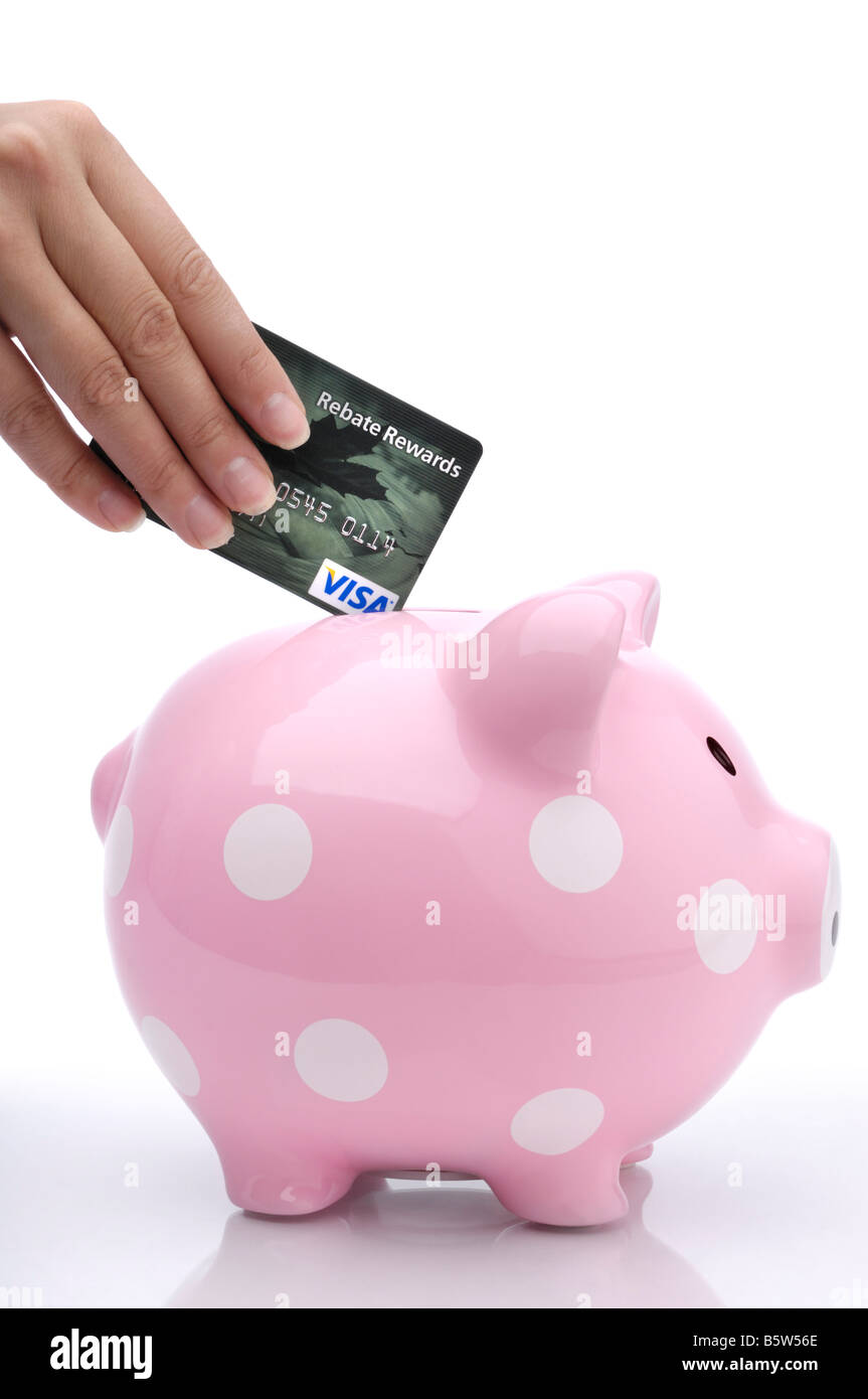 Putting credit card into piggy bank Stock Photo - Alamy