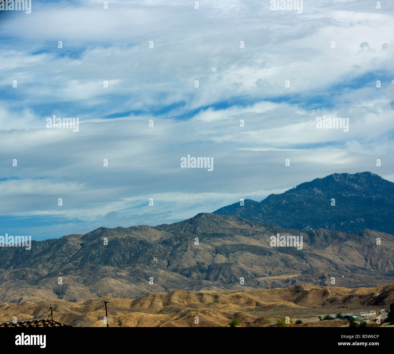 High desert community with trees cloudy skies and some structures Stock ...