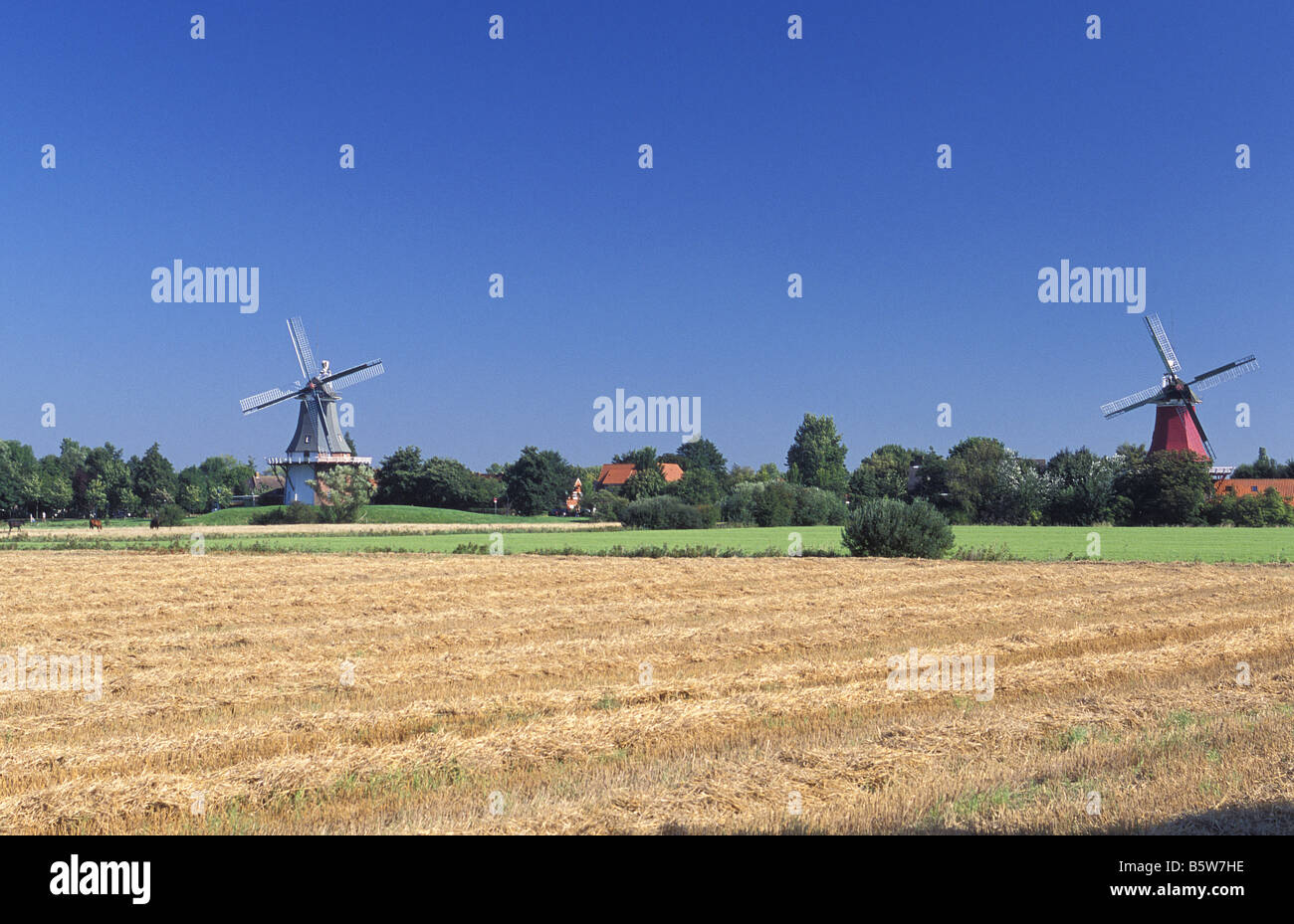 two windmills between trees Stock Photo - Alamy
