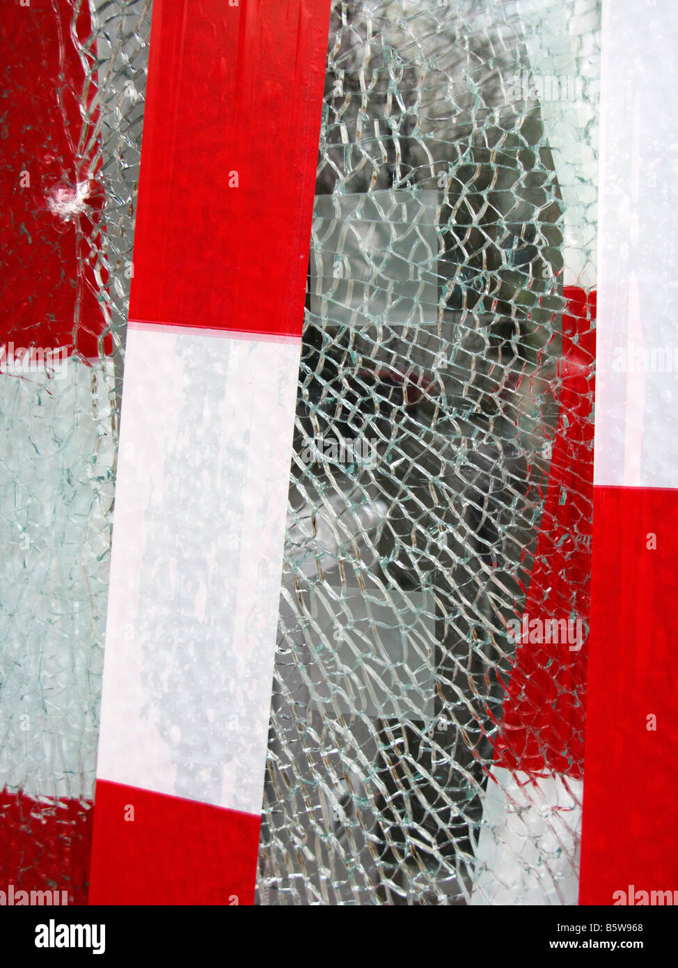 Red and white tape on shattered glass Stock Photo - Alamy