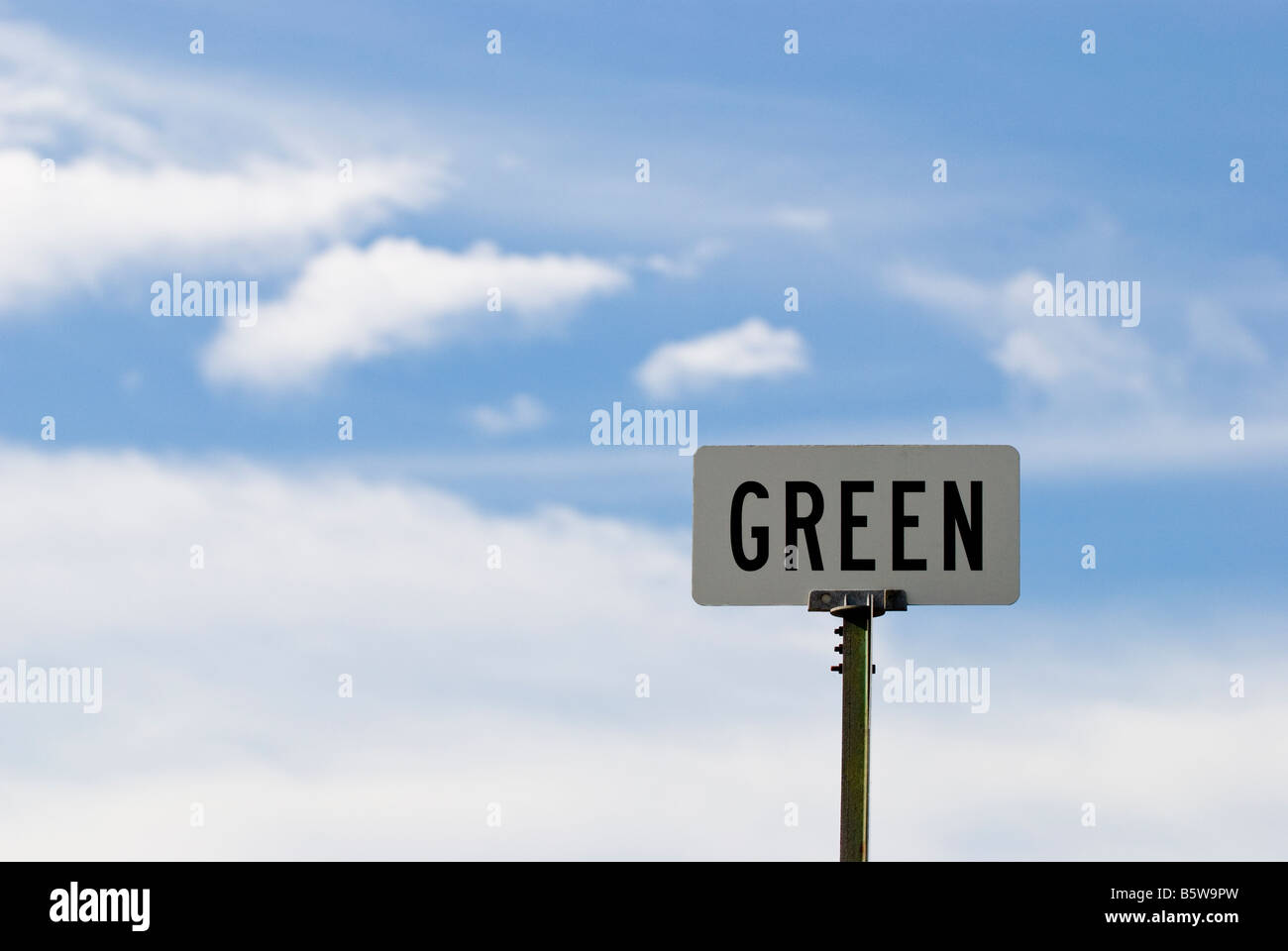 Green sign with blue sky and puffy white clouds Stock Photo - Alamy