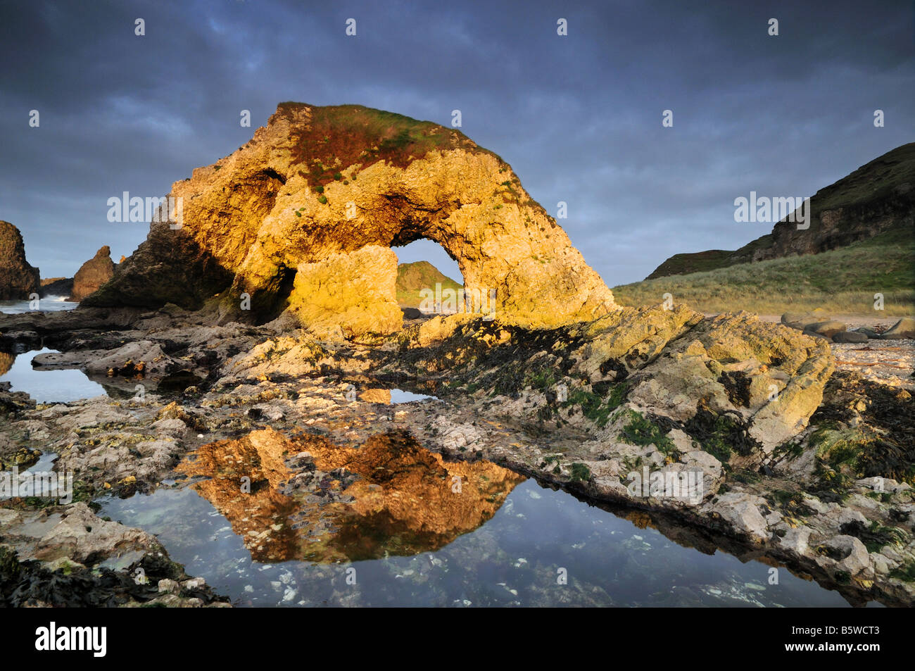 Natural stone arch on coastline at Ballintoy, Northern Ireland Stock ...