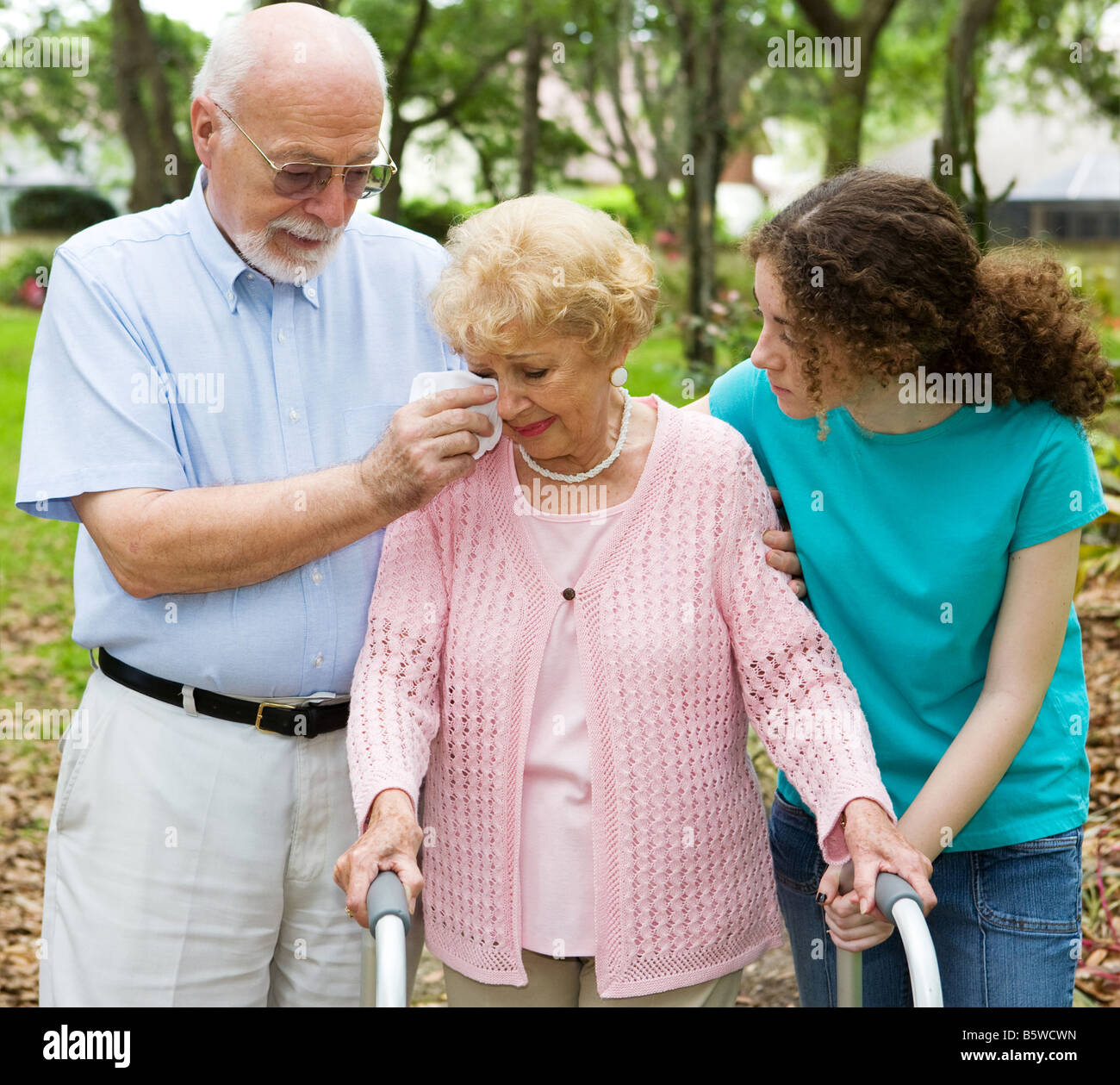 Senior woman with disability crying as her husband and granddaughter ...