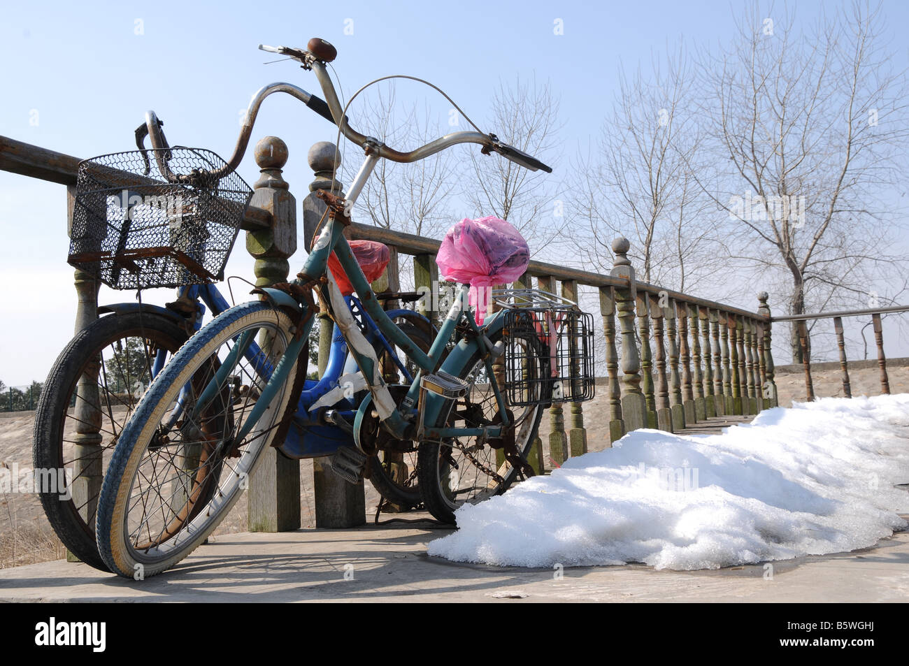 Two bicycles lean on a railing after snow Stock Photo - Alamy
