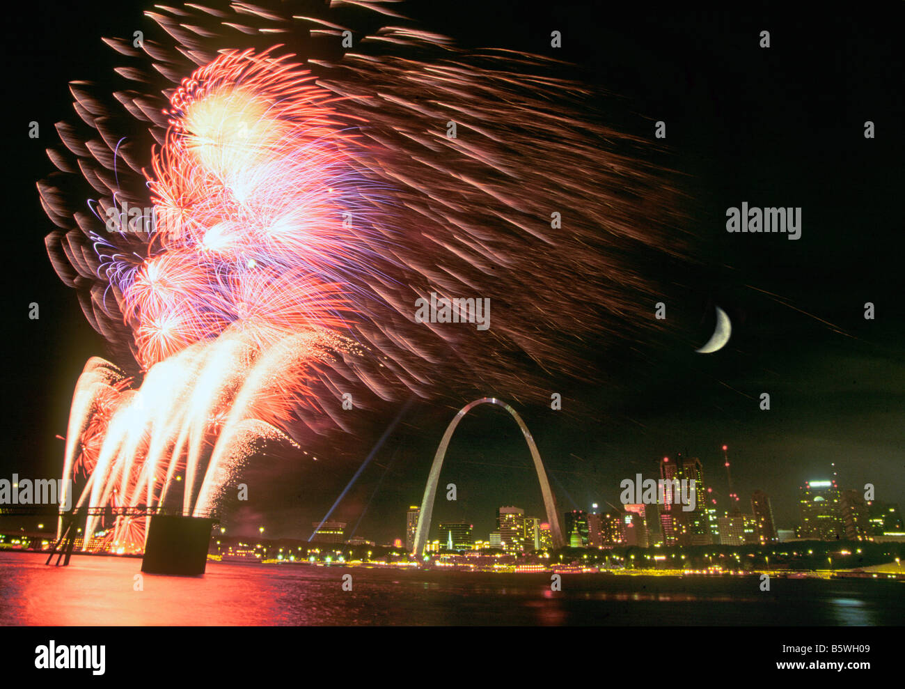 Fireworks and a quarter moon light the St Louis Arch and skyline along ...