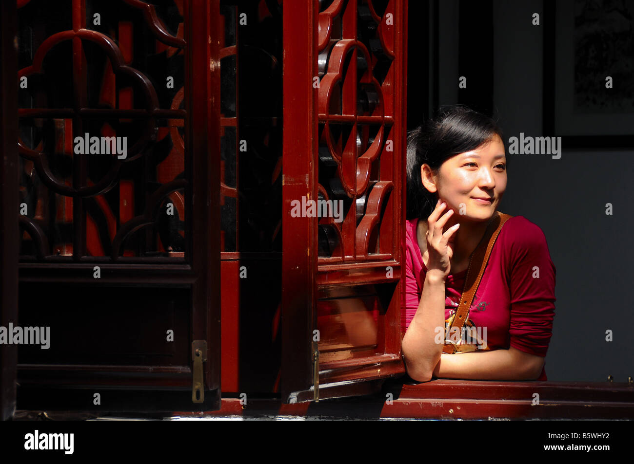 A Chinese girl lean on a triditional Chinese wooden window Stock Photo ...