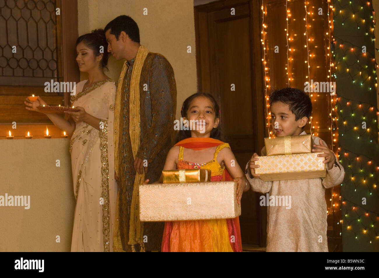 Children holding gifts with their parents holding religious offering in ...