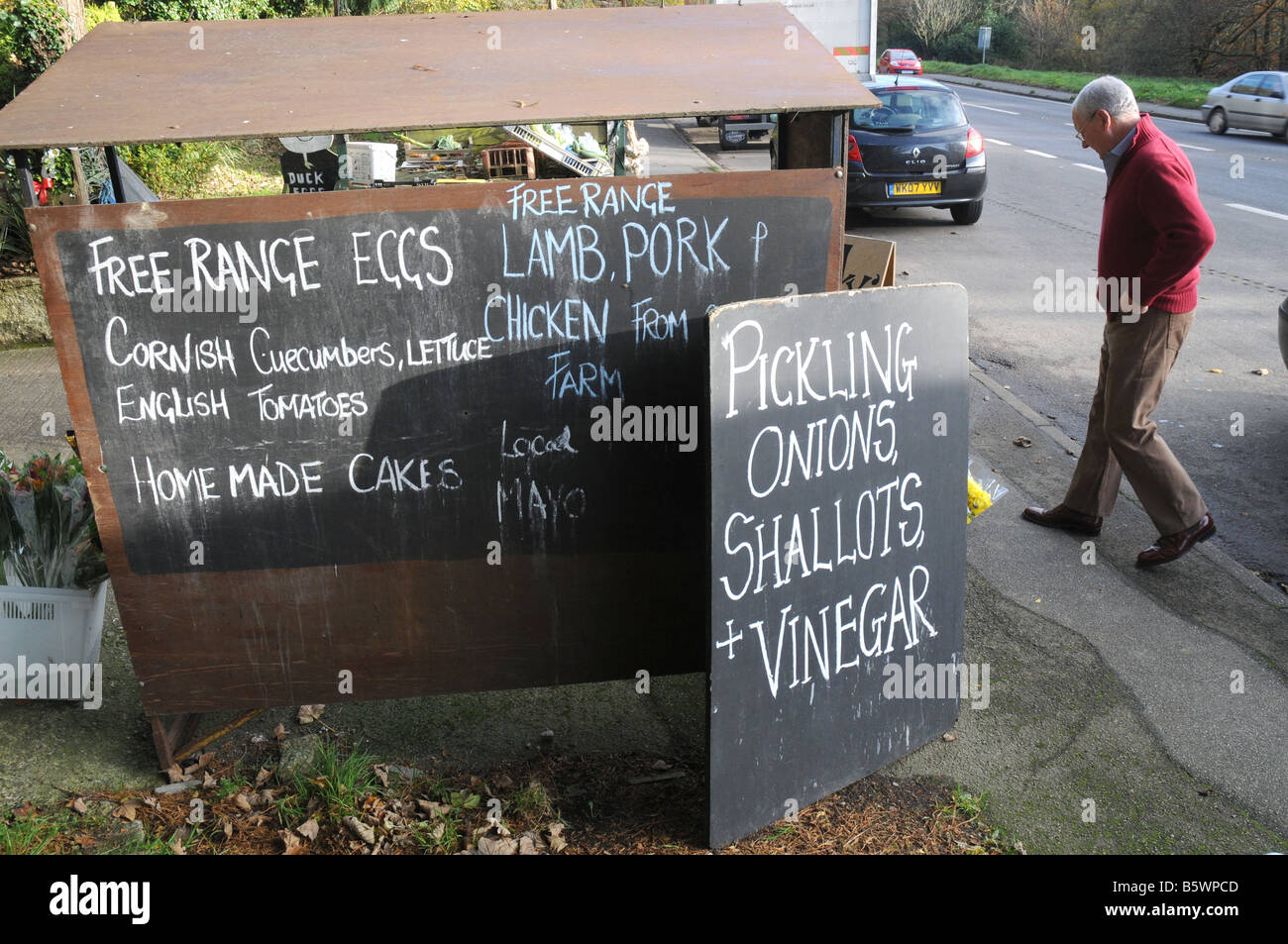 A roadside fruit and vegetable stall with a sign advertising local ...