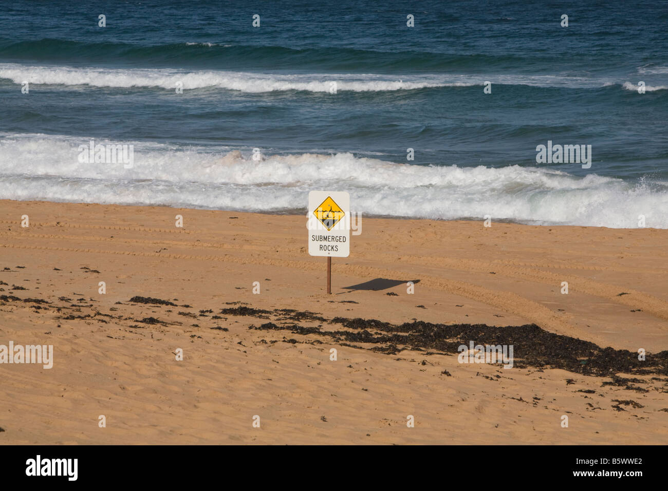 submerged rocks warning sign stuck in the sand on bilgola beach,sydney ...