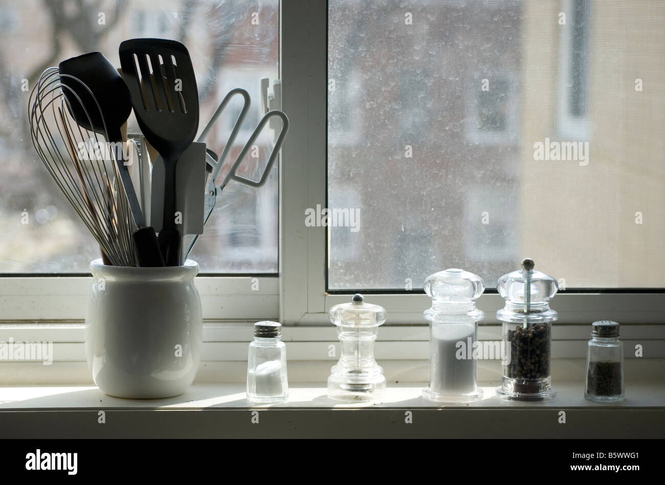 Kitchen utensils line the window sill in the sunlight Stock Photo - Alamy