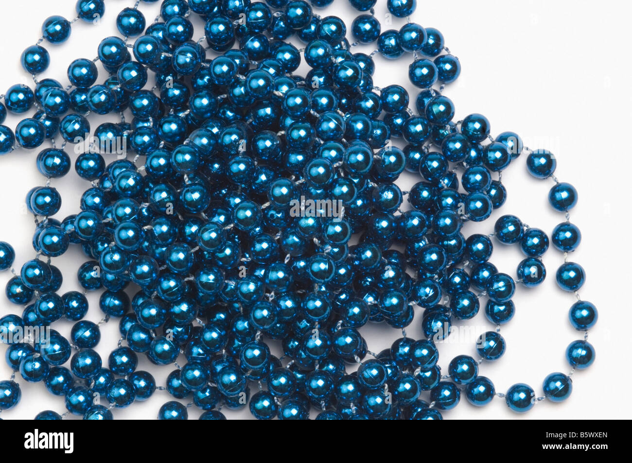 Close-up of string of blue beads on white background Stock Photo - Alamy