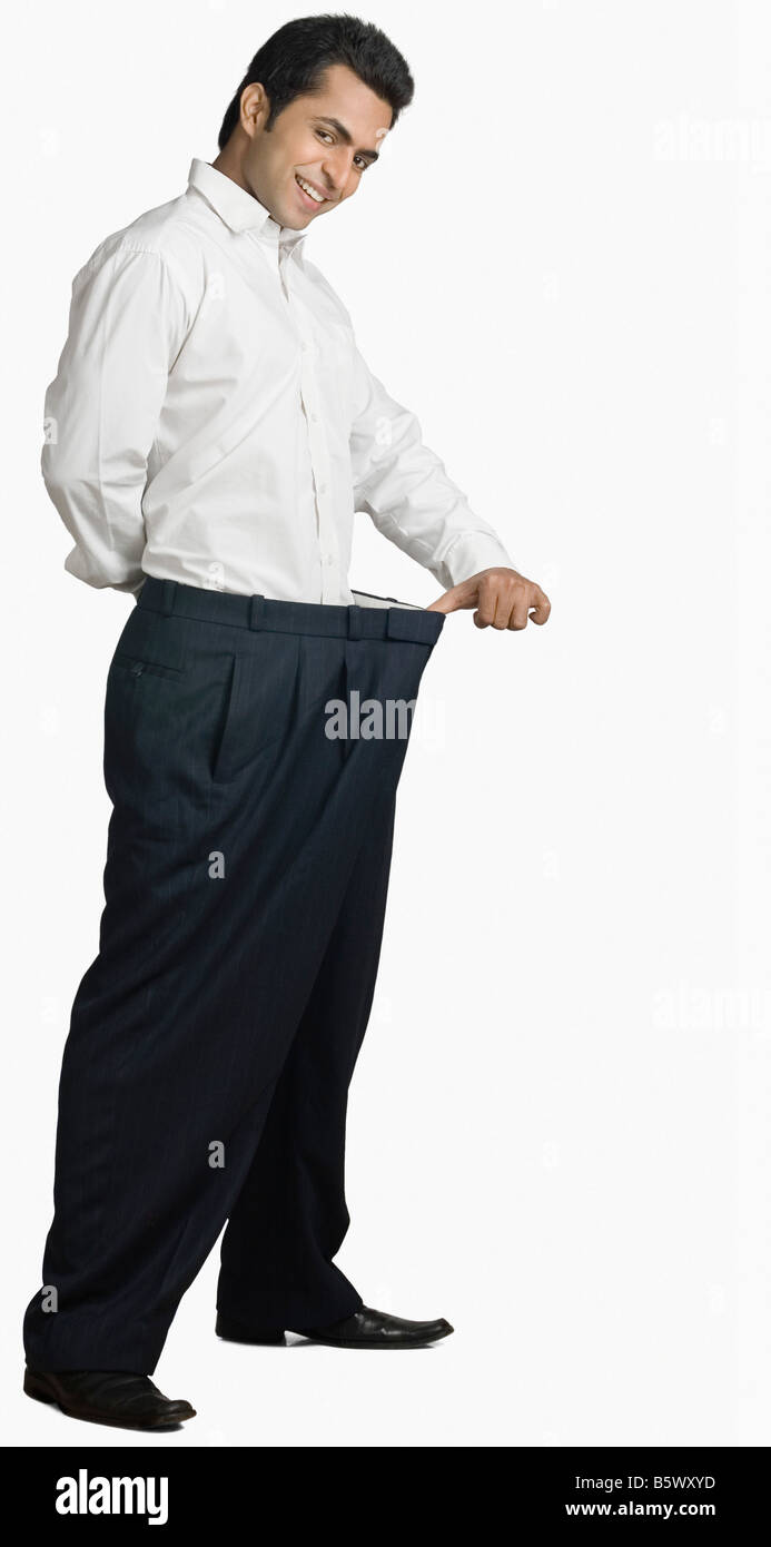 Portrait of a young man stretching his pant and smiling Stock Photo - Alamy