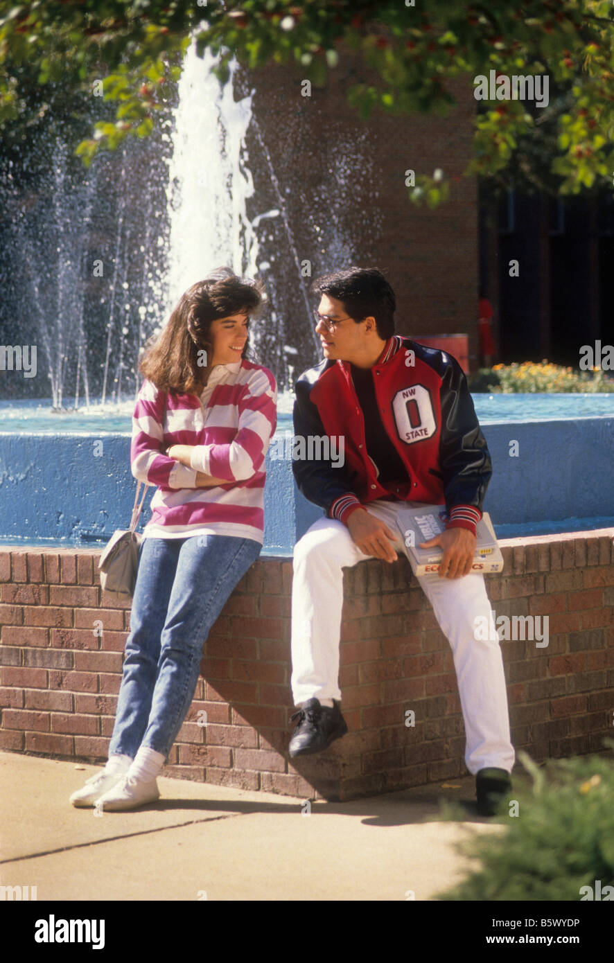 Hispanic couple talk in front of fountain on college campus Stock Photo ...